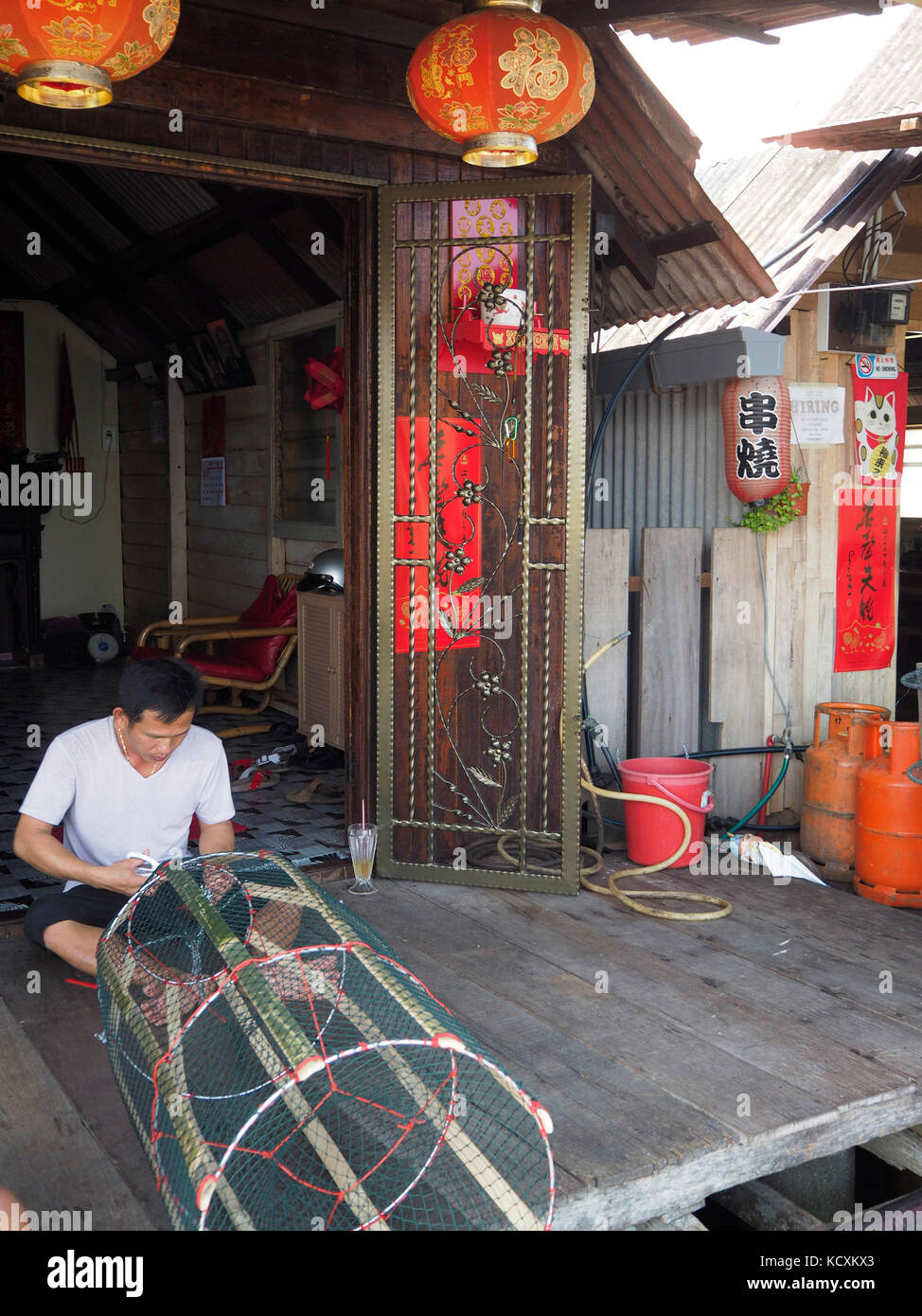 A man working on a fish trap at Chew Jetty in Penang, Malaysia Stock ...