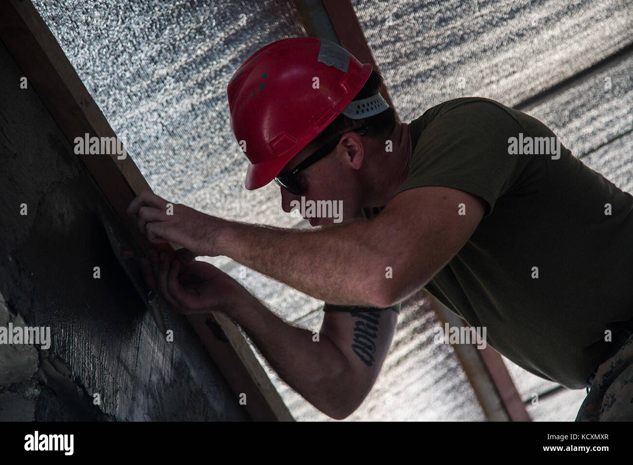 U.S. Marine Cpl. Collin Blecha spackles concrete to a wall at Esperanza ...