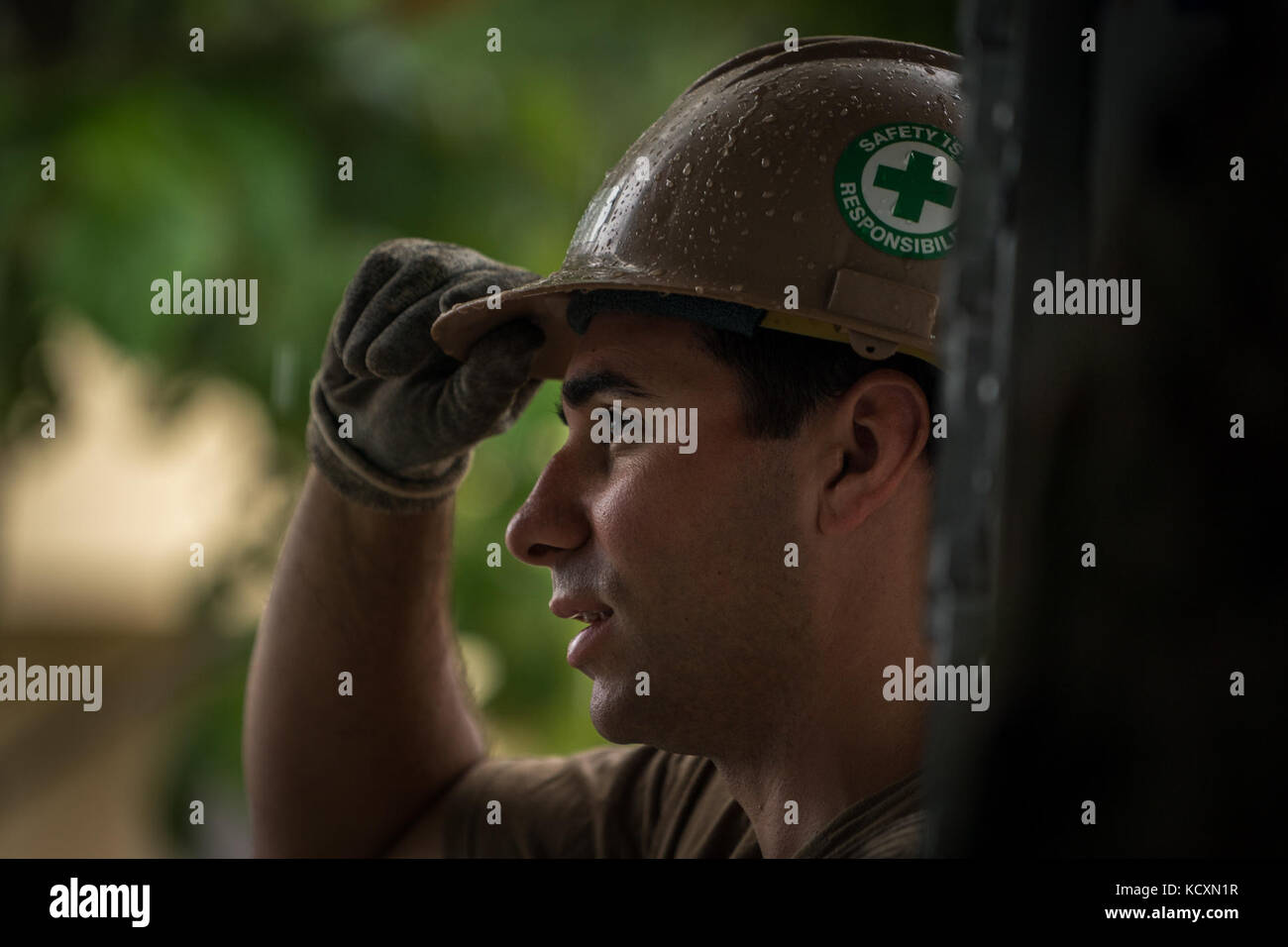 U.S. Navy BU2 Kevin Geiger readjusts his hard hat after it begins to ...