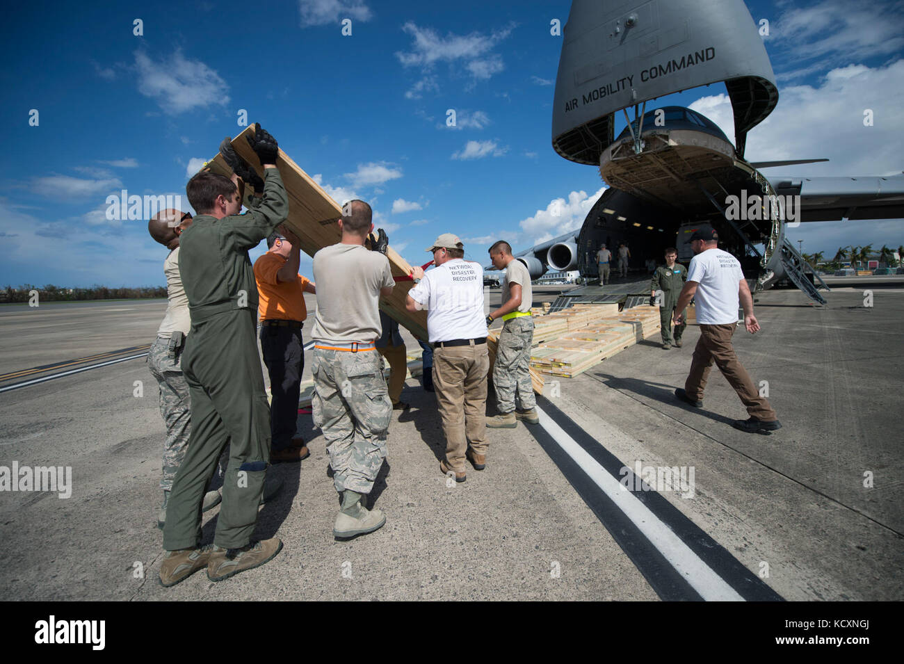 Crew members setup a ramp to unload a AT&T mobile telecommunications ...