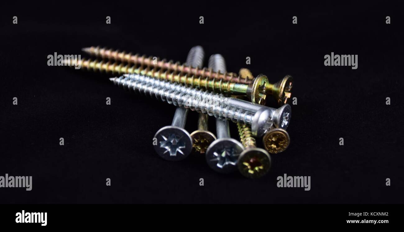 Abstract cross-head or Phillips-head or recessed-head screw on black ...