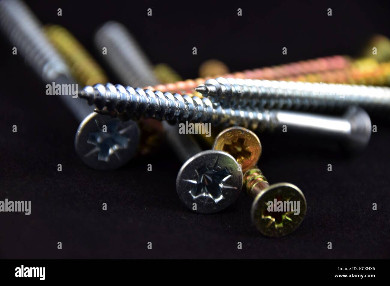 Abstract cross-head or Phillips-head or recessed-head screw on black ...