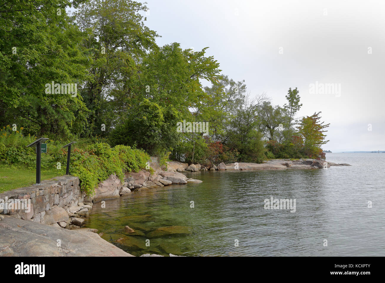 Trees rocks on the shore of a bay along the St Lawrence River at the ...