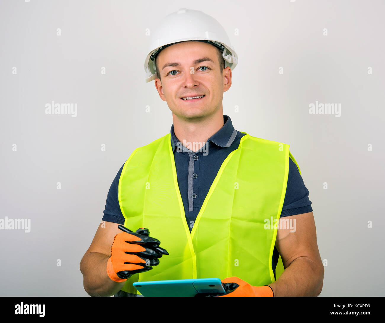 Builder in a helmet and vest Stock Photo - Alamy