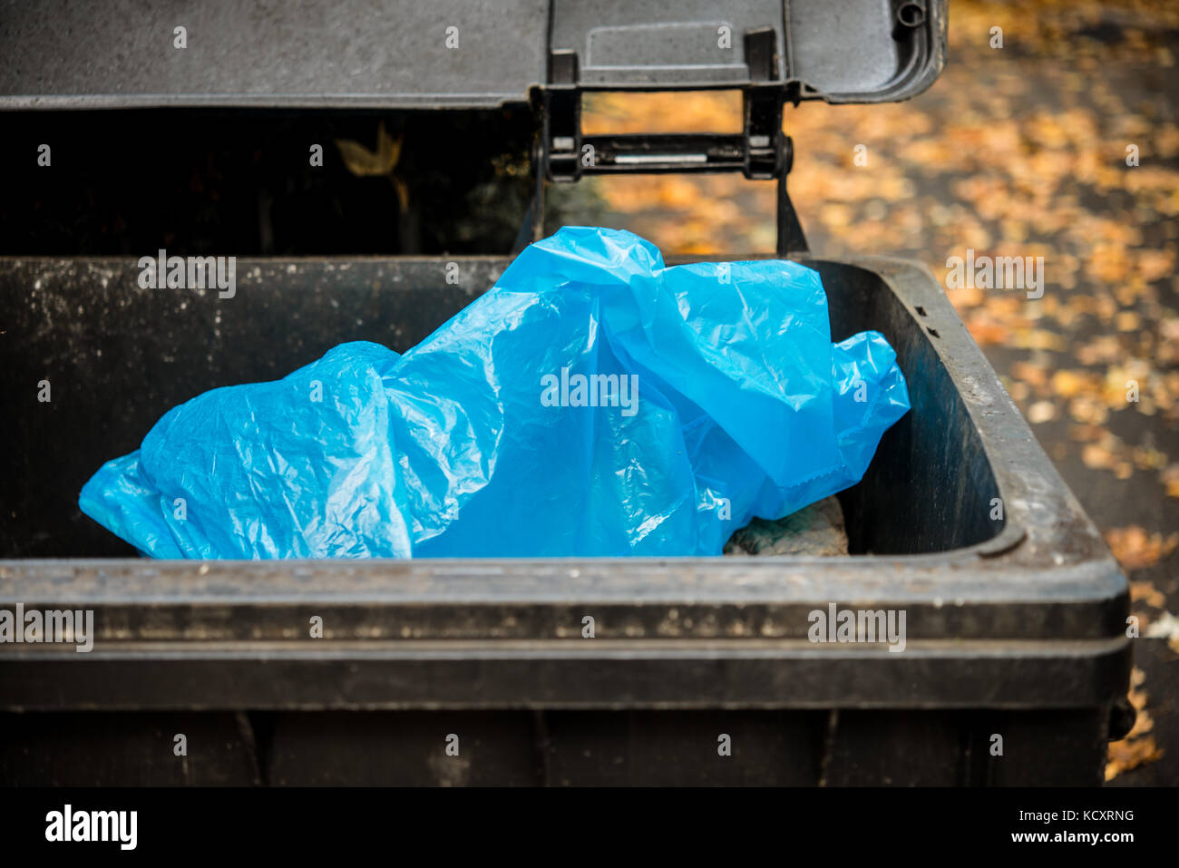 Open trash bin with blue plastic bag Stock Photo - Alamy