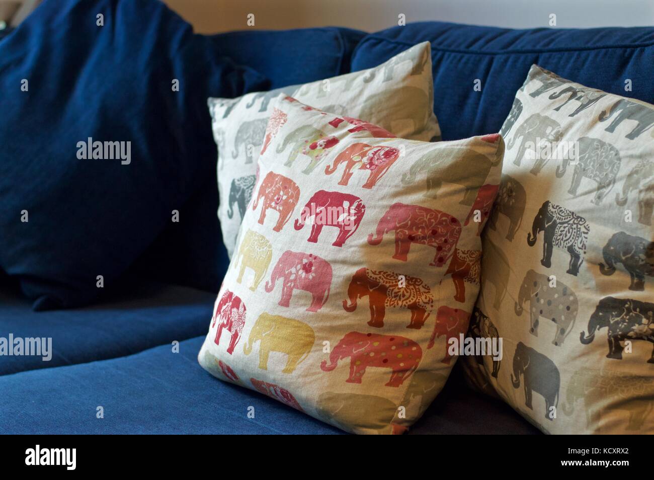 Elephant patterned cushions on blue sofa Stock Photo - Alamy
