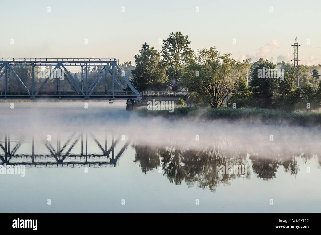 Railway bridge above misty lake. Reflection on water surface Stock ...