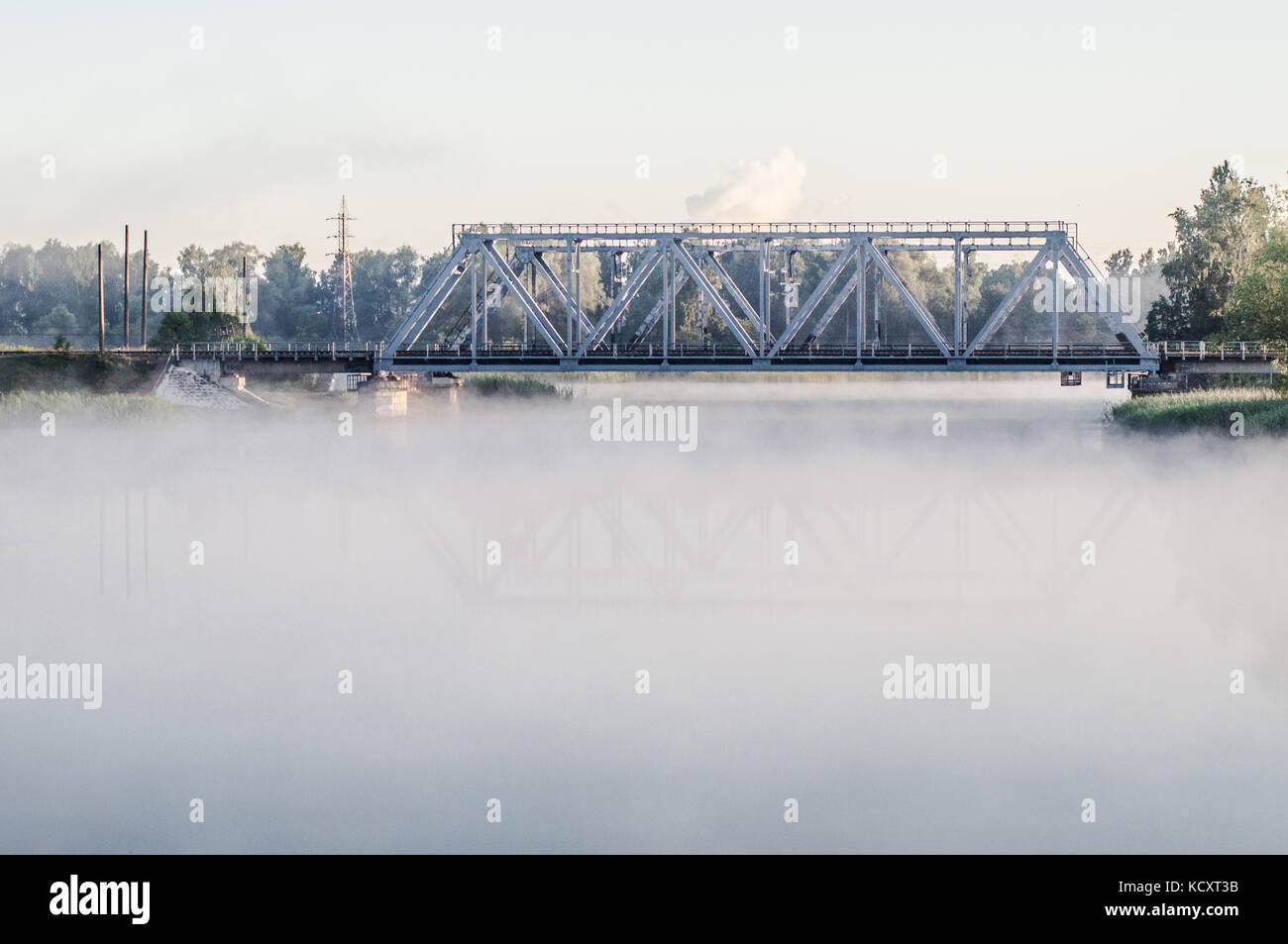 Railway bridge above misty lake. Reflection on water surface Stock ...