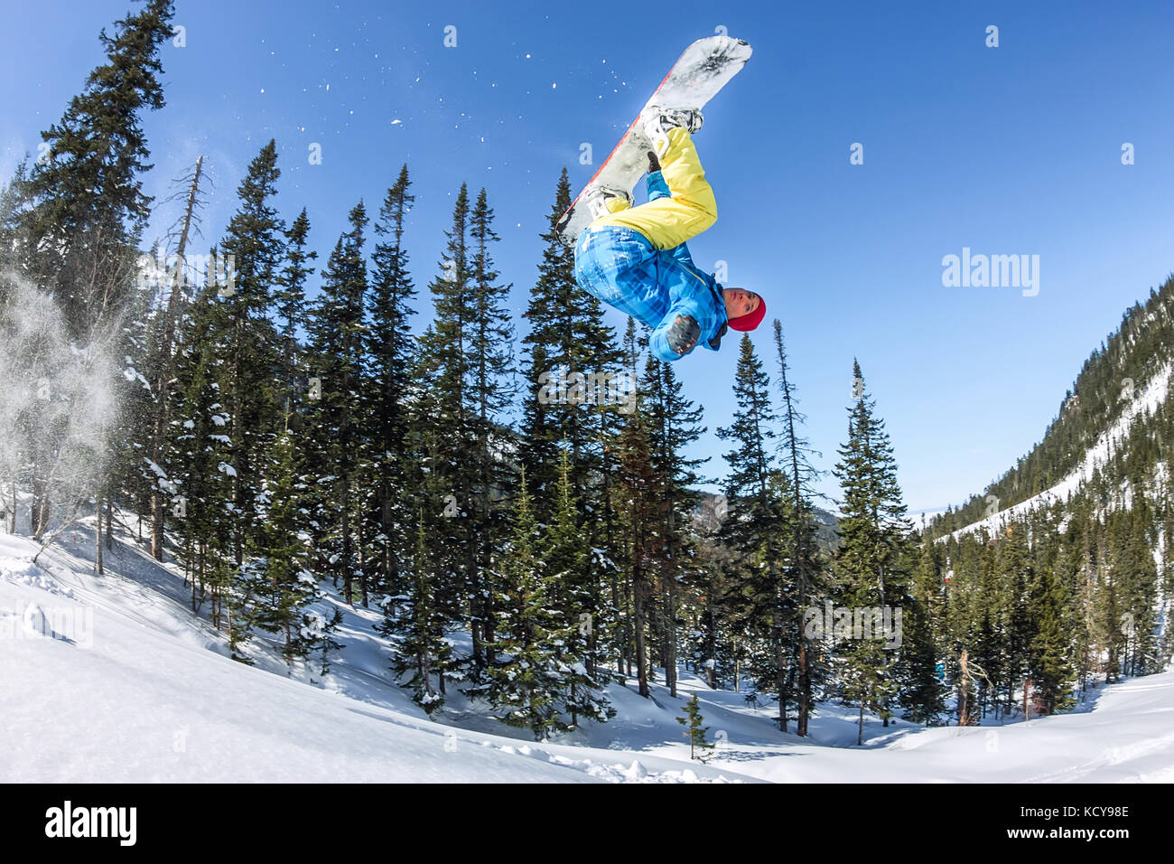 Snowboarder freerider jumping from a snow ramp in the sun on a ...