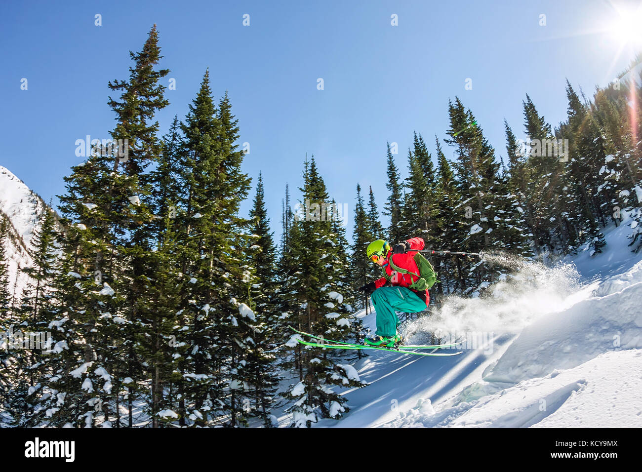 Skier freerider jumping from a snow ramp in the sun on a background of ...