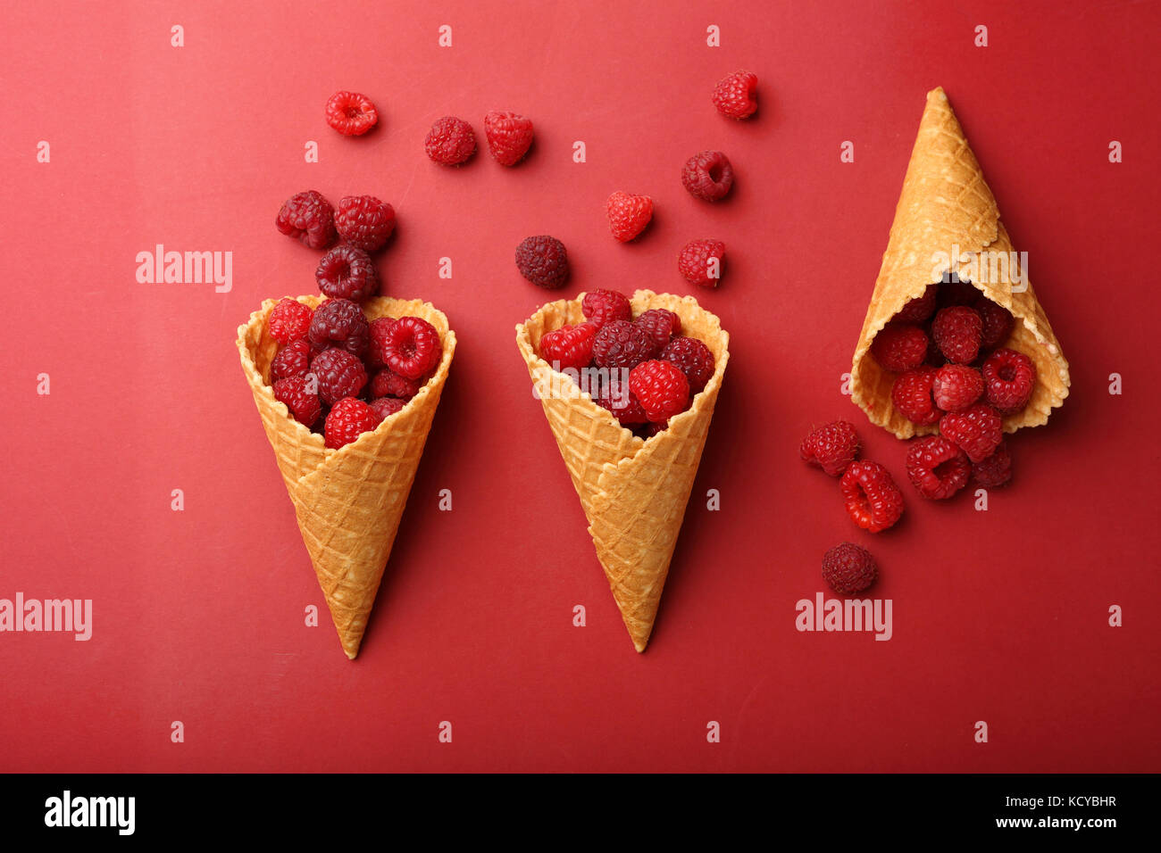 raspberry in waffle cones on red background, food above Stock Photo - Alamy