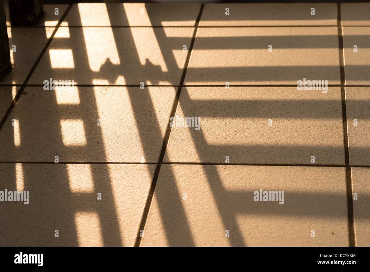 Detail of balcony railing as shadow on tiles and joints Stock Photo - Alamy
