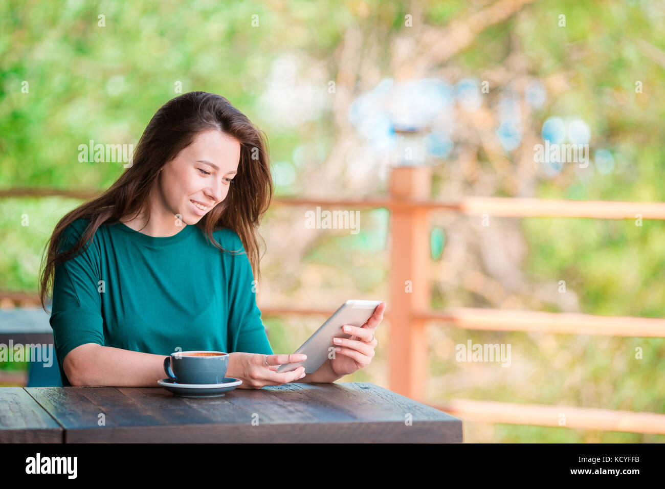 Young charming woman calling with cell telephone while sitting alone in ...