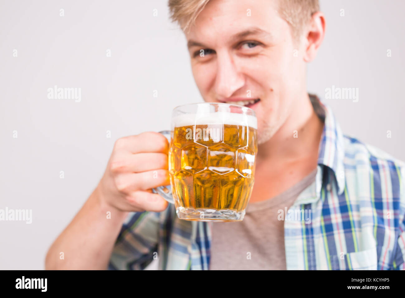 Man drinks beer. Handsome young guy drinking lager pint on white ...
