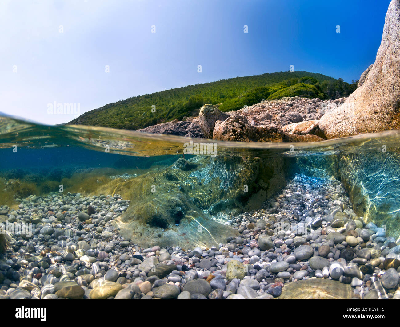 Half underwater in the sea with rocks and stones Stock Photo - Alamy