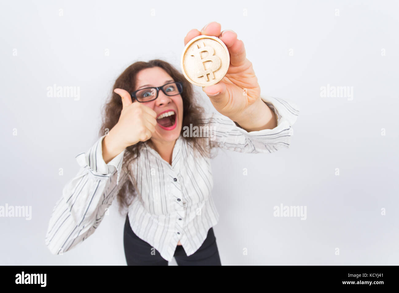 Laughing business woman showing Golden Bitcoin coin and thumbs up ...