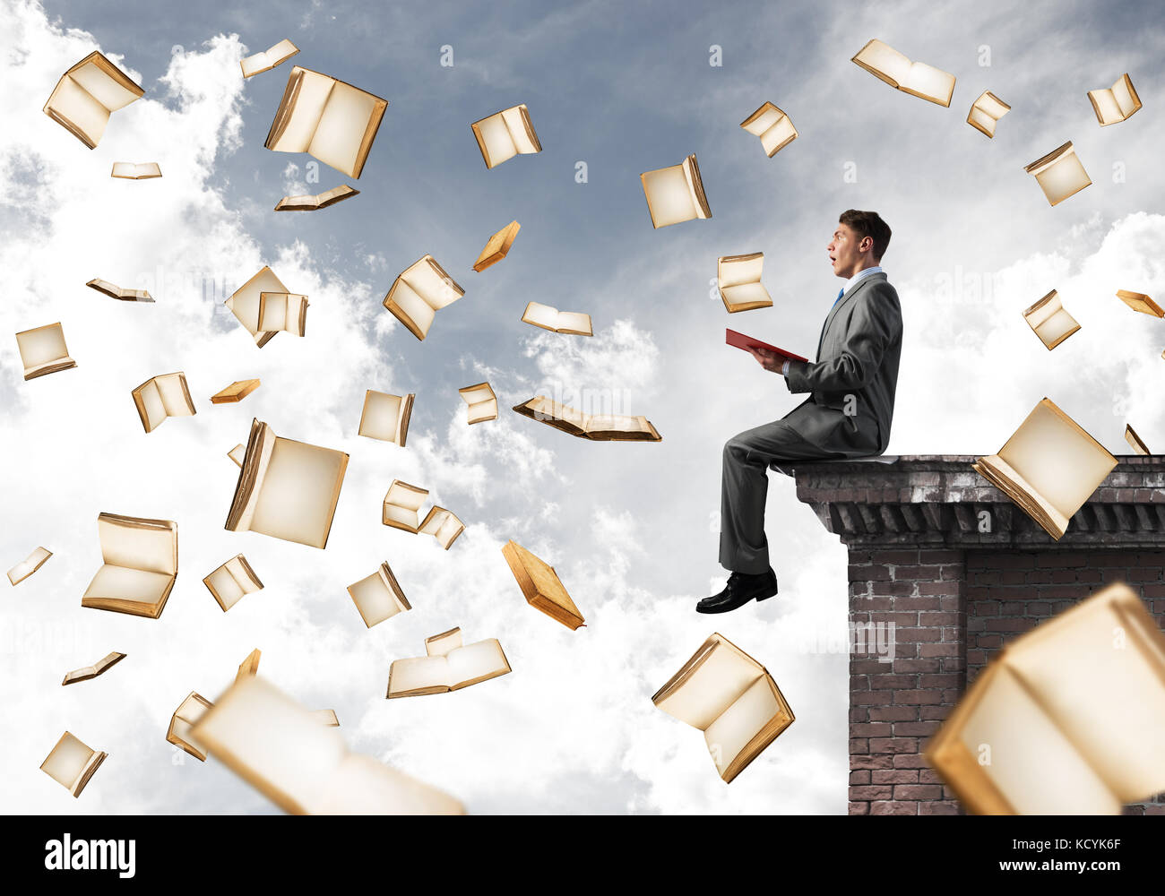 Man reading book and many of them flying in air Stock Photo - Alamy