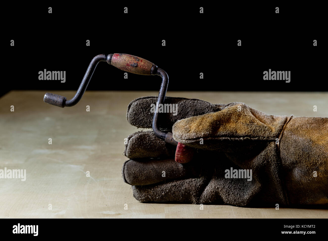 Hand in glove with tool for work in workshop. Hand protected by working ...