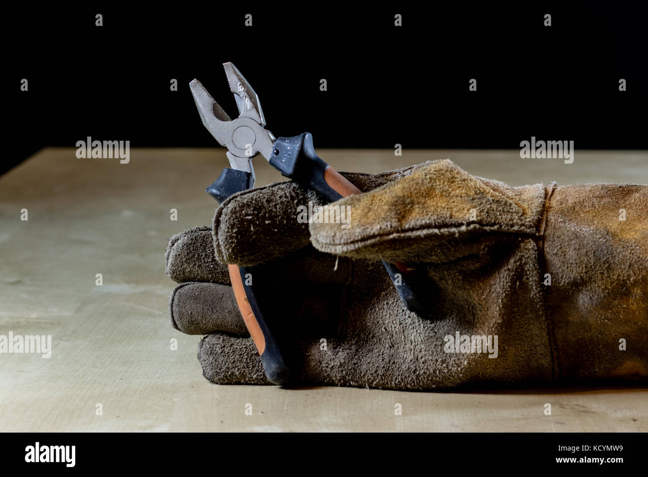 Hand in glove with tool for work in workshop. Hand protected by working ...
