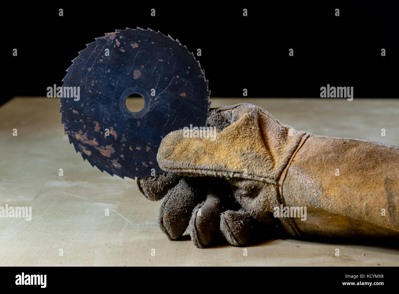 Hand in glove with tool for work in workshop. Hand protected by working ...