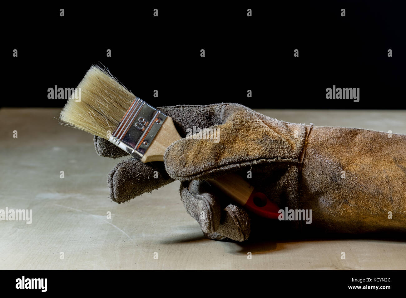 Hand in glove with tool for work in workshop. Hand protected by working ...