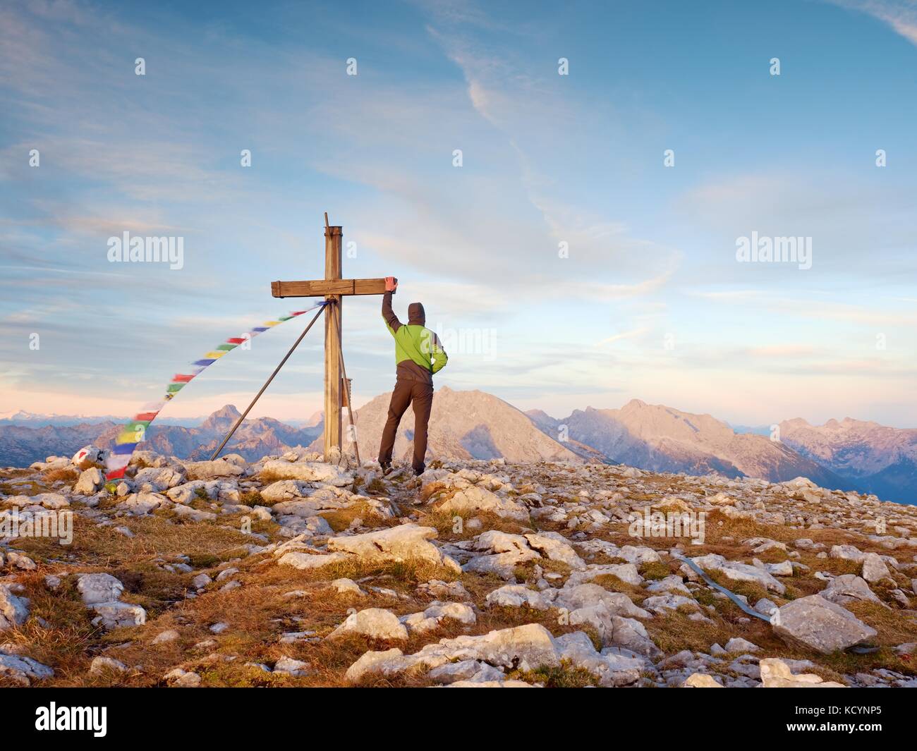 Tourist stand on rocky view point and watching into misty Alpine valley ...