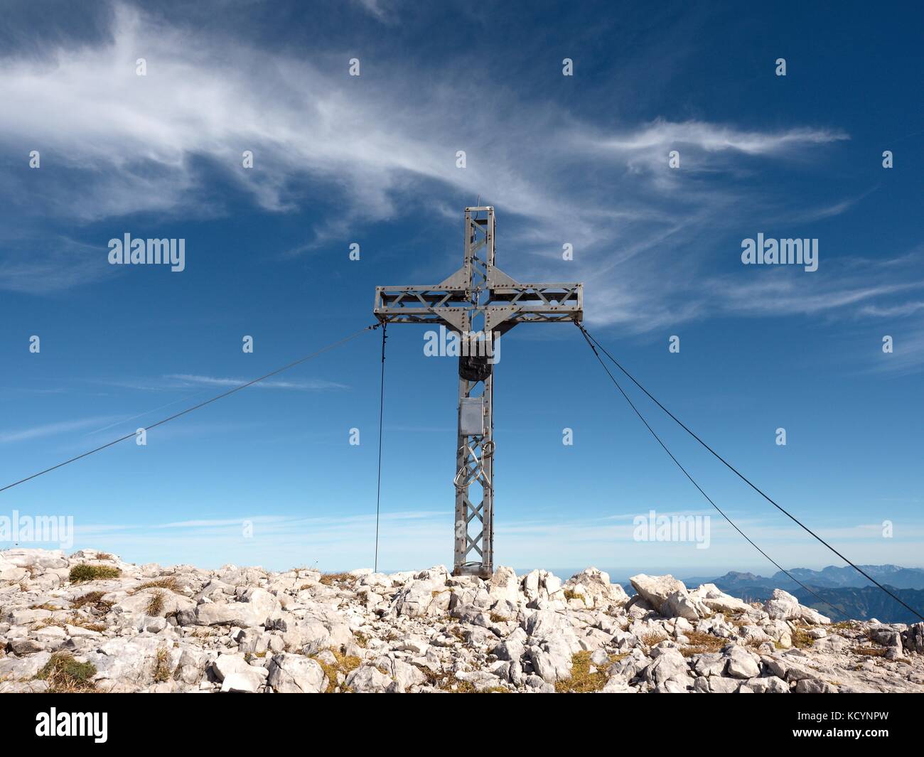 Steel cross raised at mountain summit in Alps. Sharp peak. Daybreak Sun ...