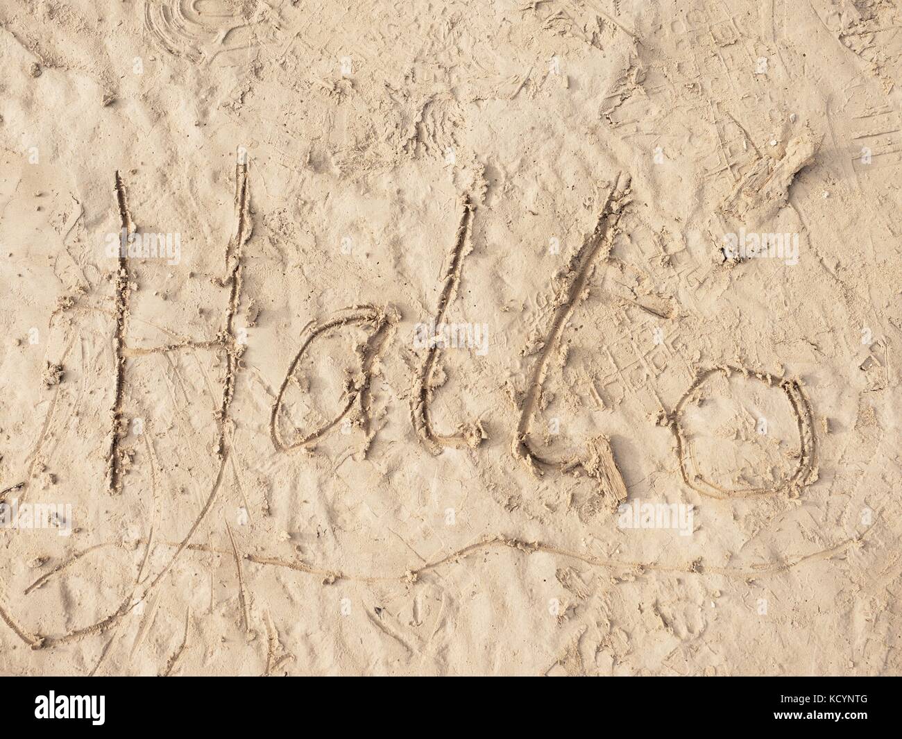 Children drawing of word hallo in sand on beach of bay. Letters written ...