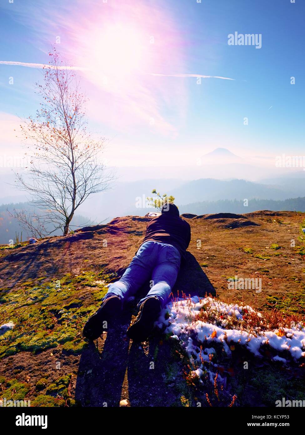 Man lay down and taking photo by mirror camera on neck. Snowy rocky ...