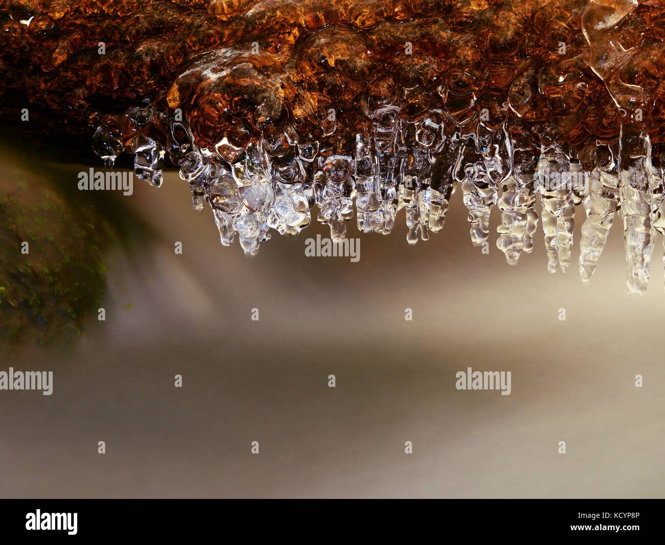 Icicles above freeze winter mountain stream. Winter season at river ...