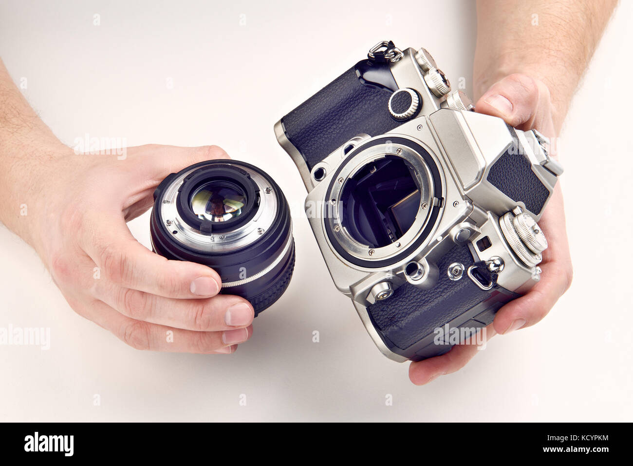 Retro photo SLR camera and lens in the hands of the photographer ...