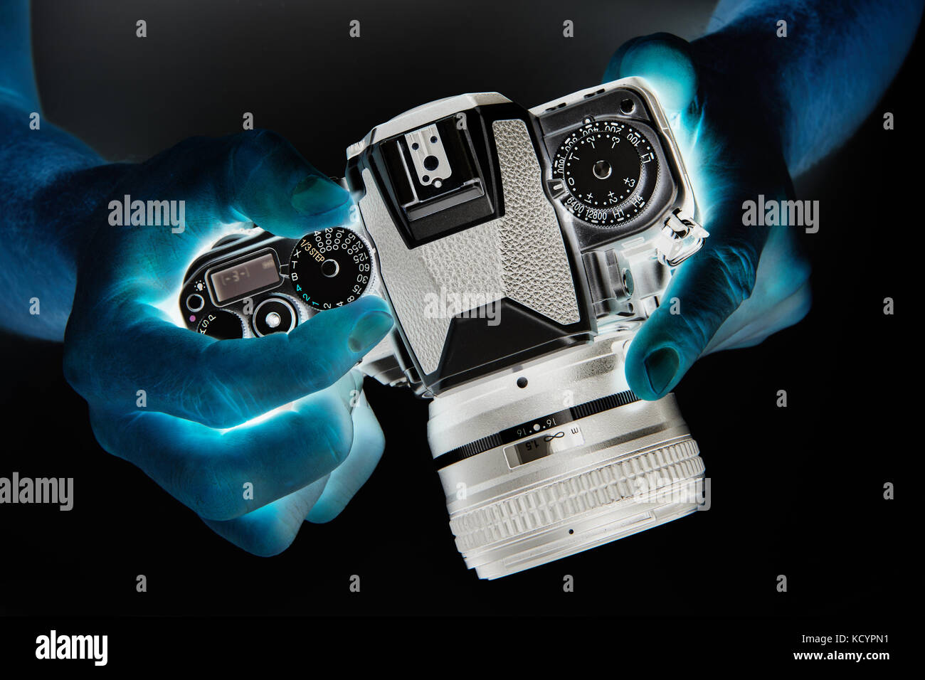 Negative photo of SLR camera in the hands of the photographer closeup ...