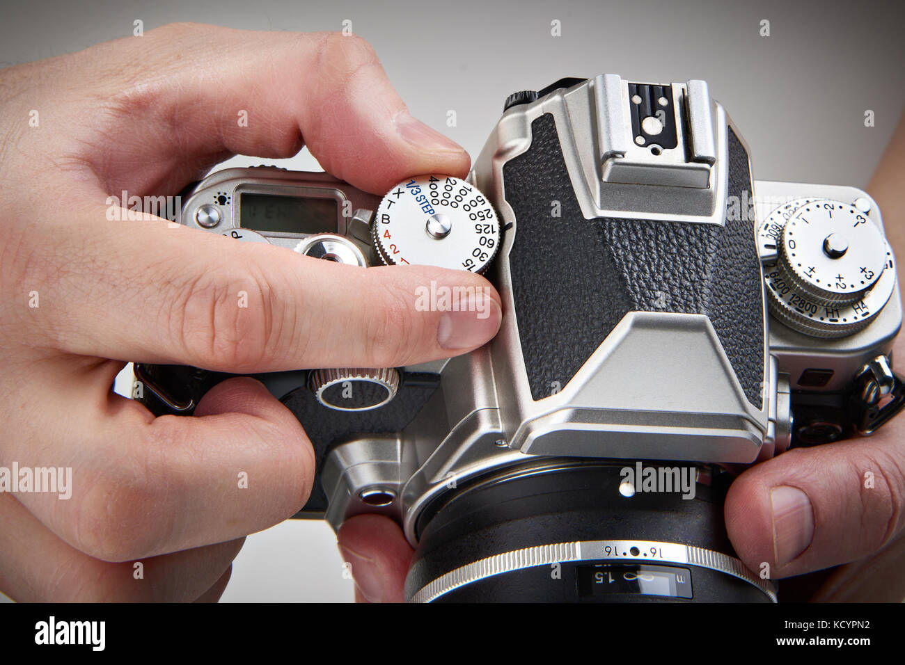 Photographer setting shutter control dial on retro SLR camera closeup ...