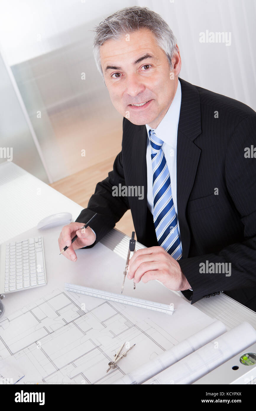 Portrait Of Mature Architect Male With Blueprint In The Office Stock ...