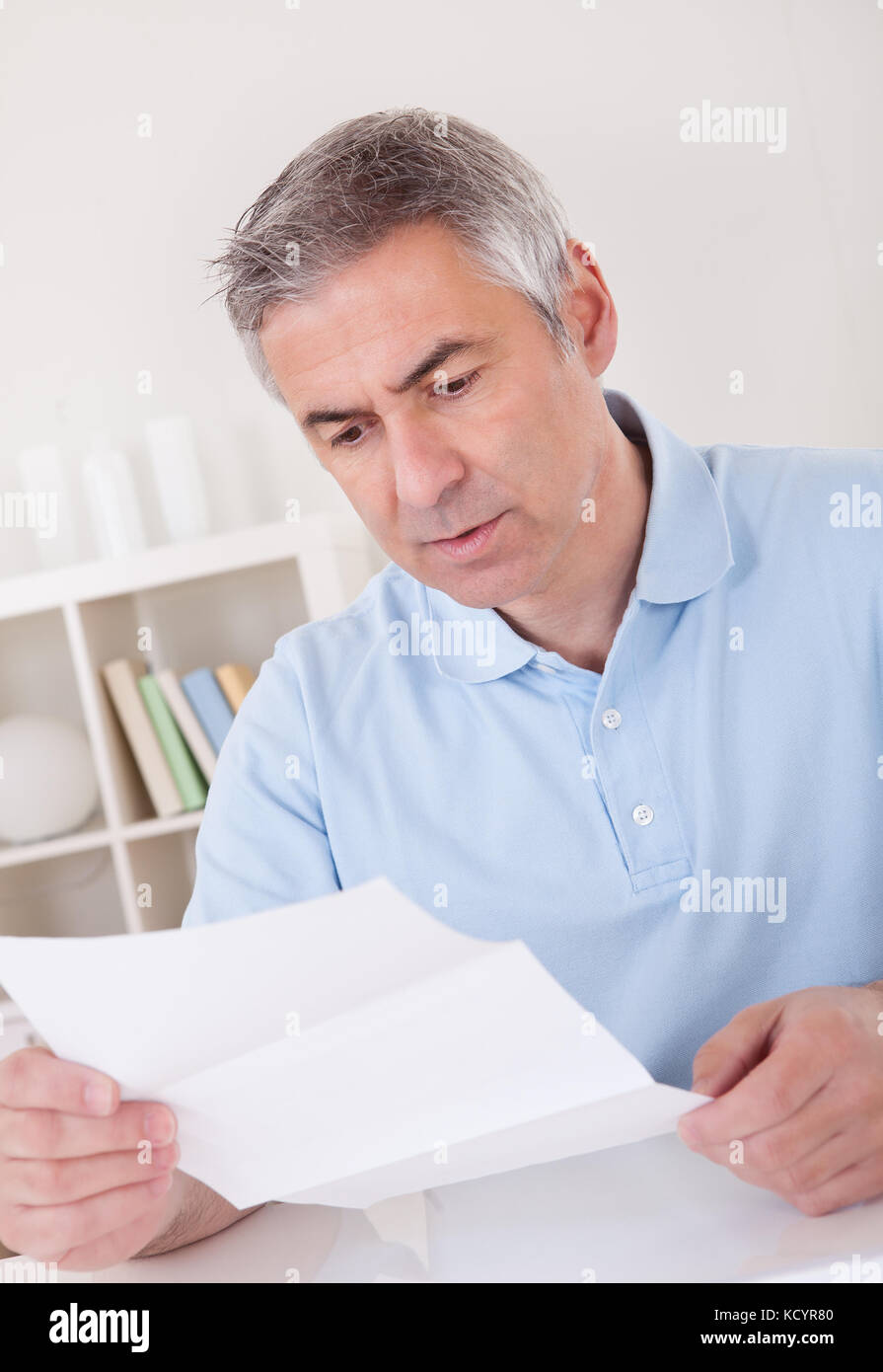 Horrified old man reading a document with an aghast expression Stock ...