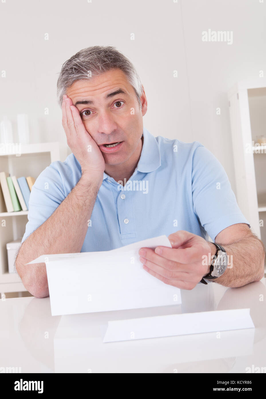 Horrified old man reading a document with an aghast expression Stock ...
