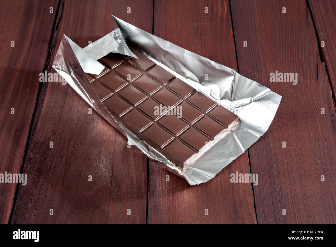 Chocolate bar in wrapper on the dark wooden background. Top view Stock ...