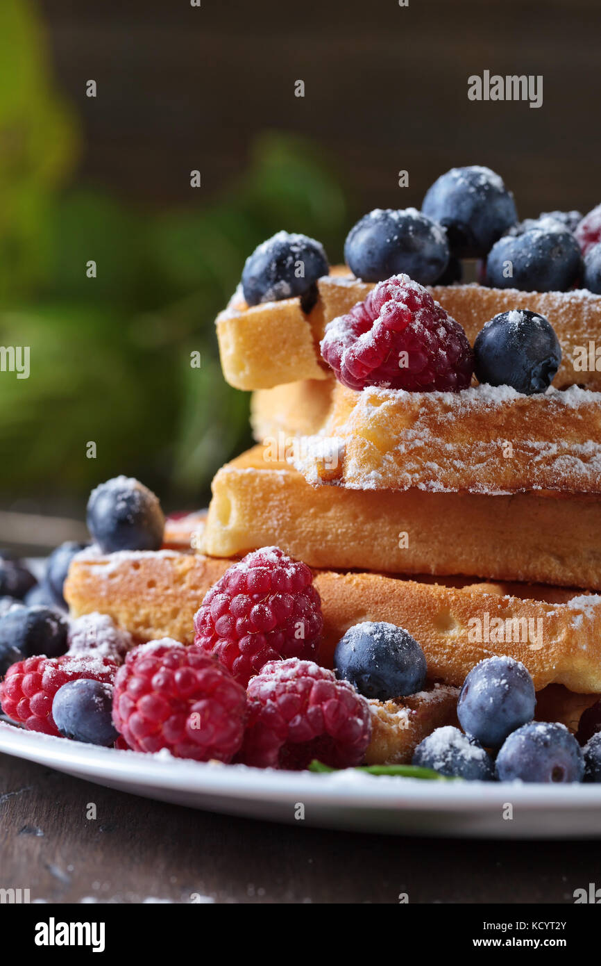 Waffles with raspberry and blueberry on a old wooden table Stock Photo ...