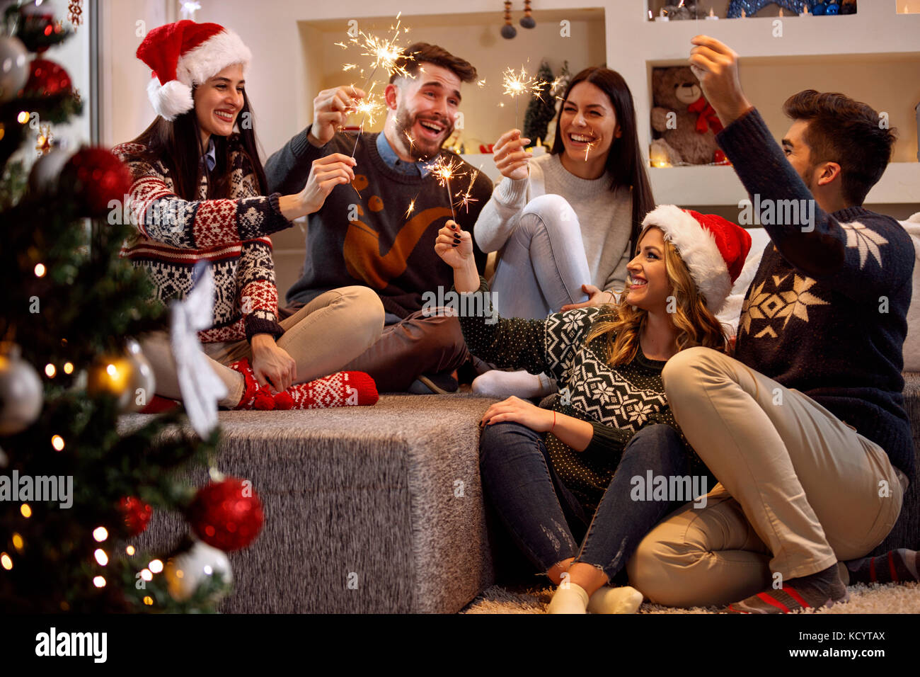 Happy friends with sparkle celebrating Christmas day Stock Photo - Alamy