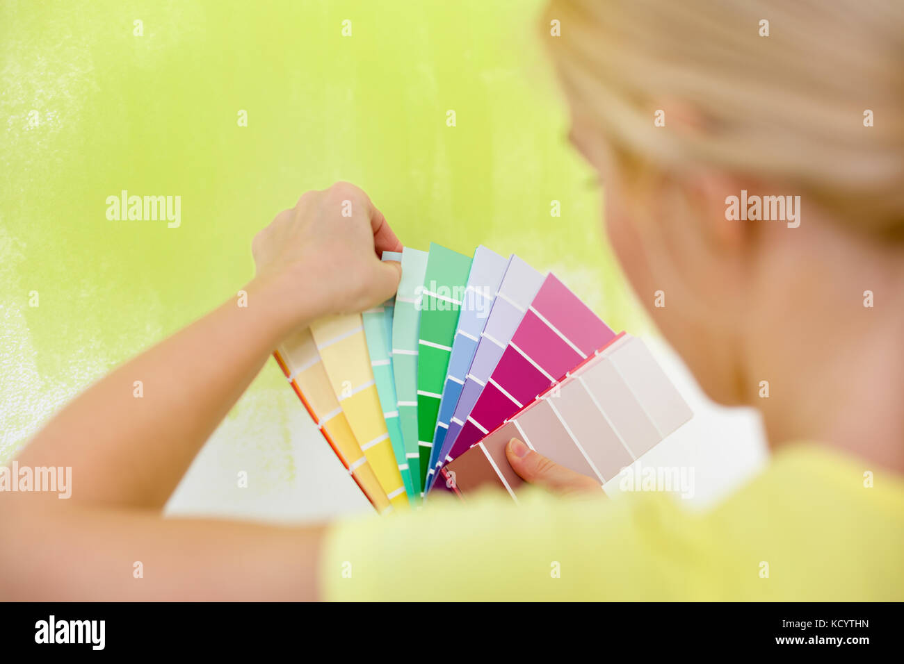 Woman choosing color for painting wall Stock Photo - Alamy