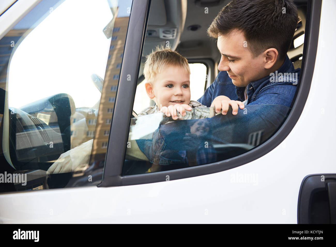 Portrait of cute little kid looking out of car window and smiling ...