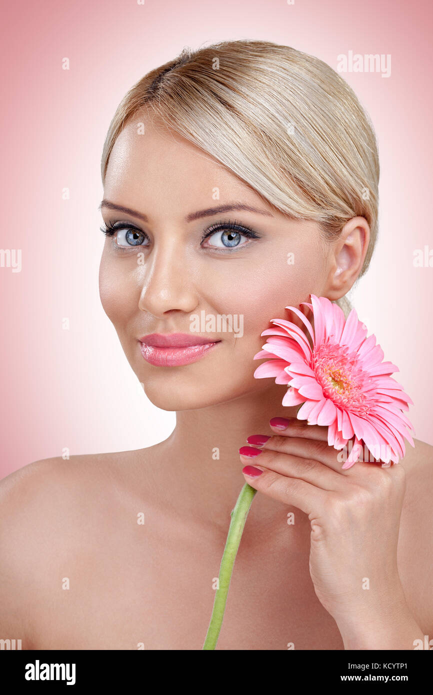 Young beautiful, tender woman posing with pink flower Stock Photo - Alamy