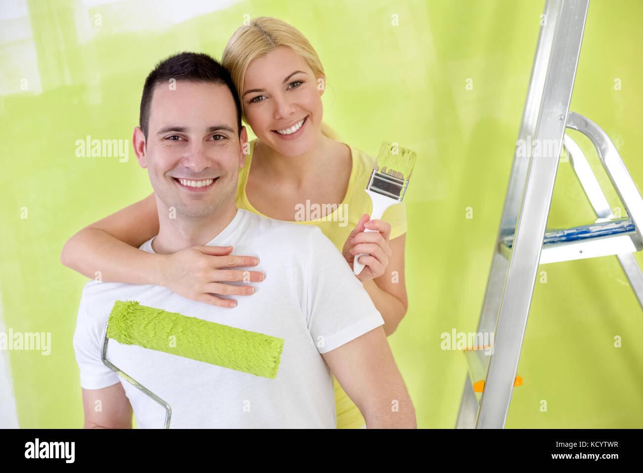 Young affectionate, happy handy couple painting new house Stock Photo ...