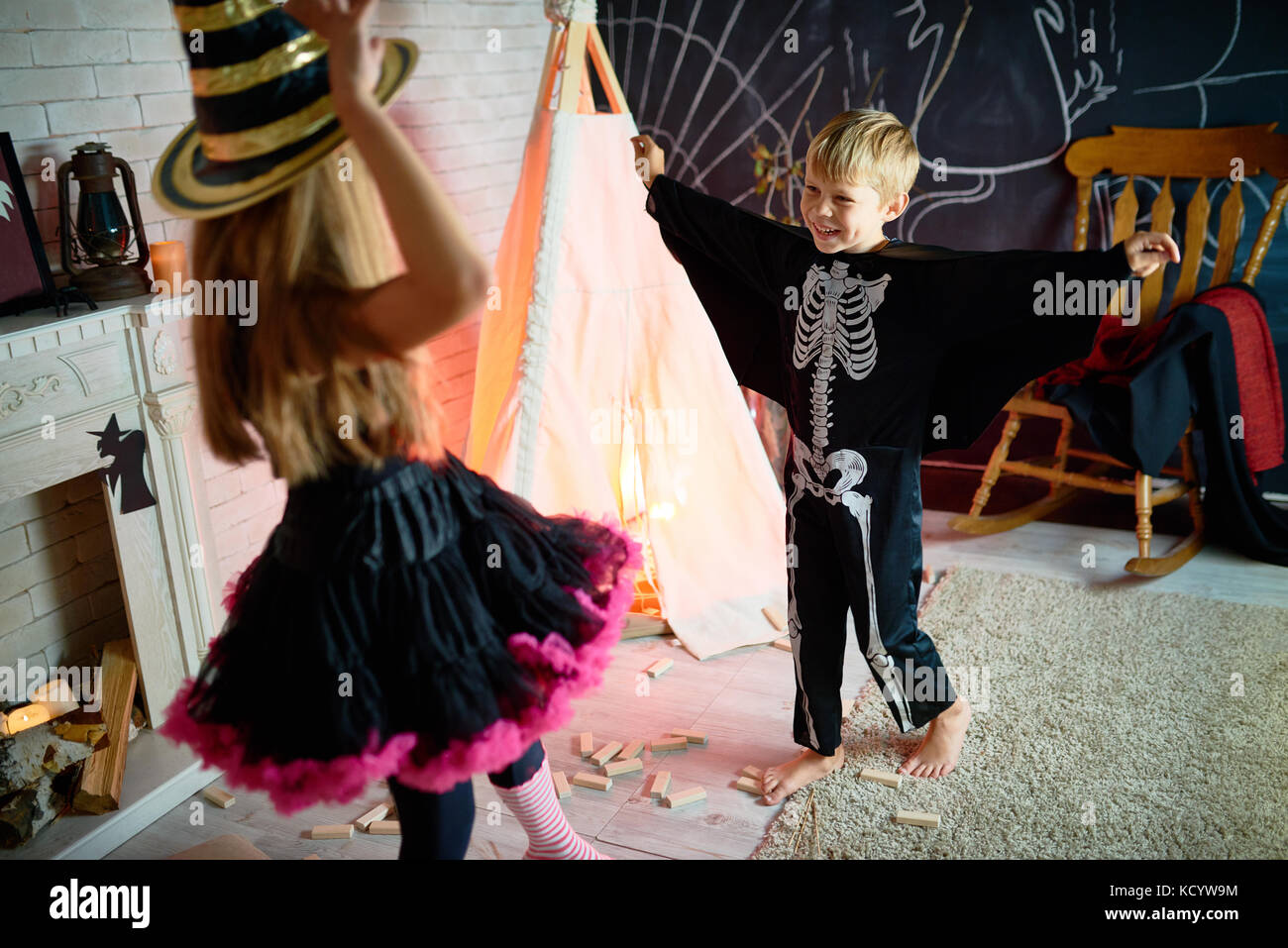 Portrait of two kids wearing Halloween costumes having fun playing in ...