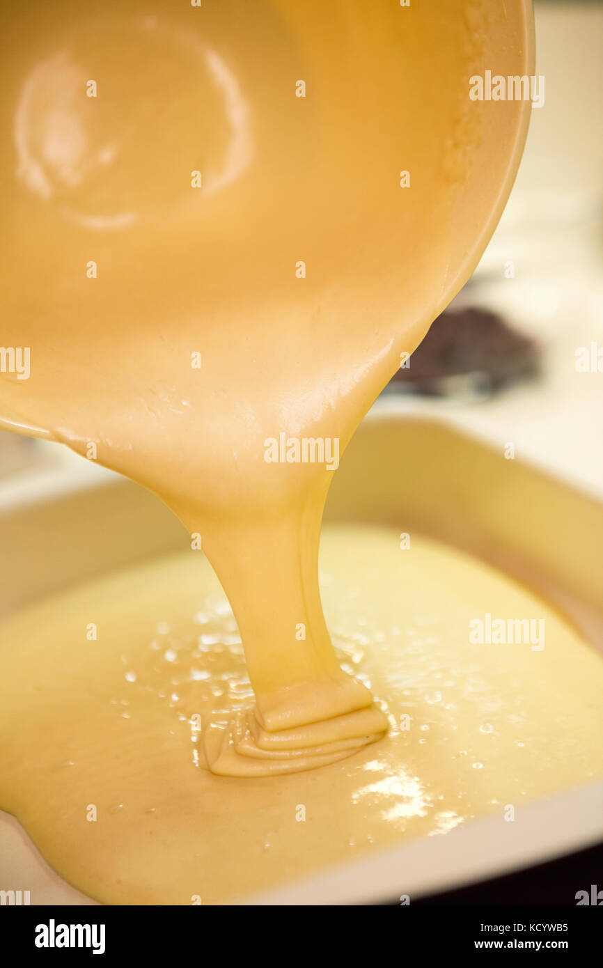 Pouring mixture of eggs and flour in baking pan Stock Photo - Alamy