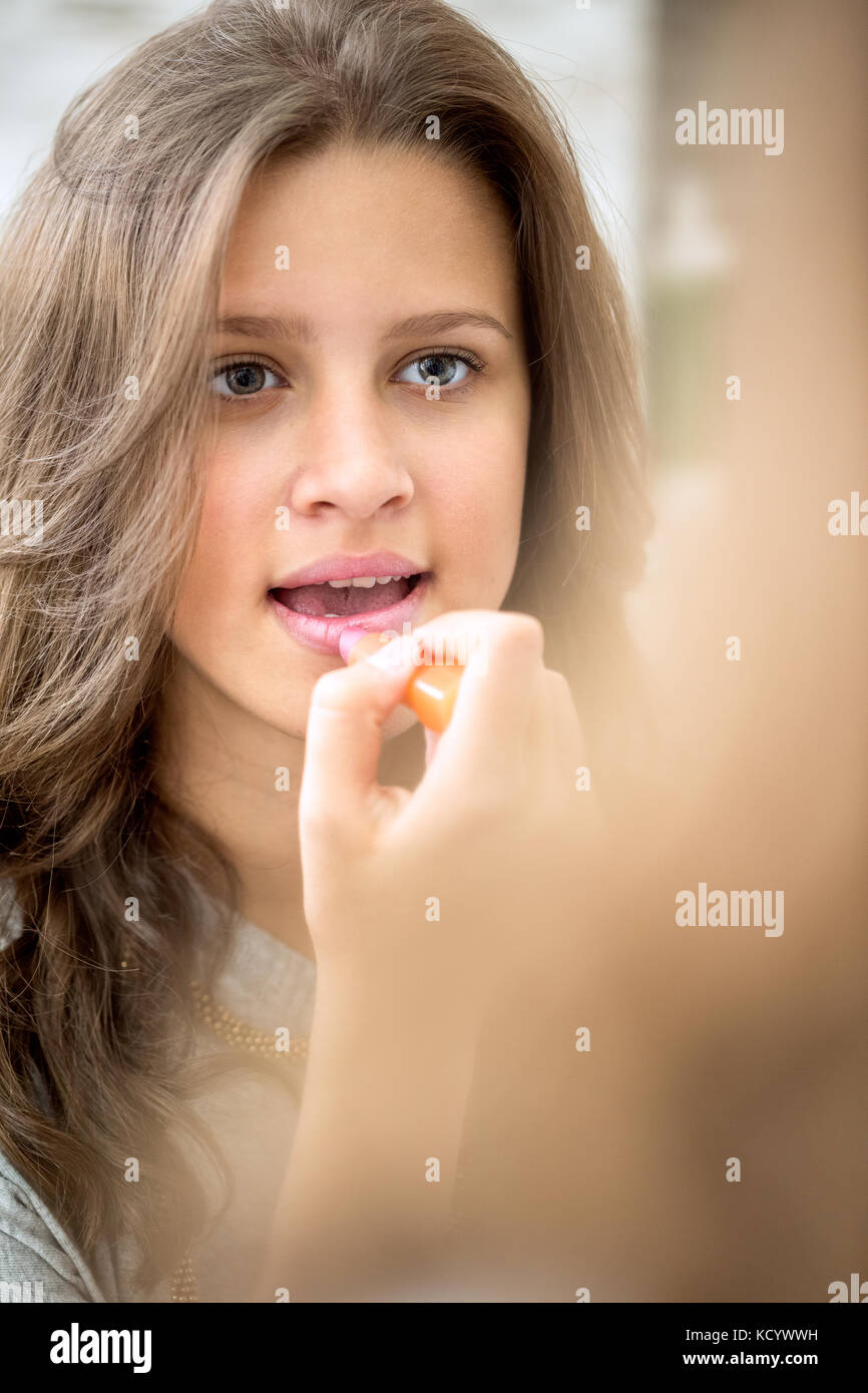 Teen girl putting on lipstick hi-res stock photography and images - Alamy