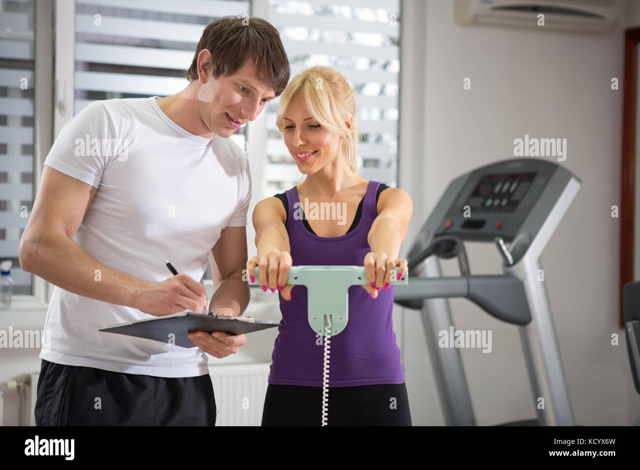Personal trainer working with his client at gym Stock Photo - Alamy