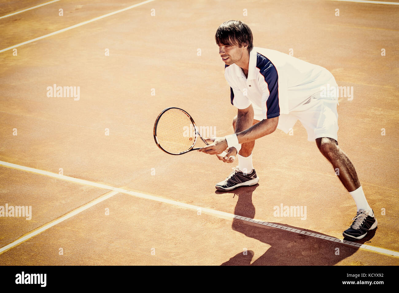 young man play tennis outdoor on orange tennis court Stock Photo - Alamy