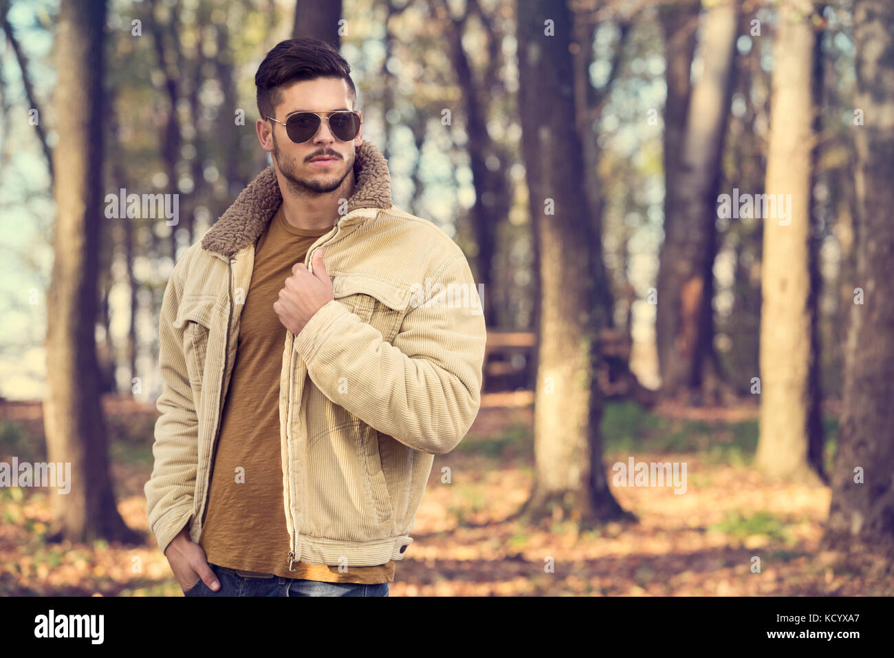 Stylish man with sunglasses posing in autumn park Stock Photo - Alamy