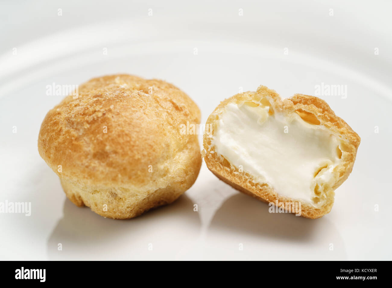 profiteroles on plate closeup one sliced Stock Photo - Alamy